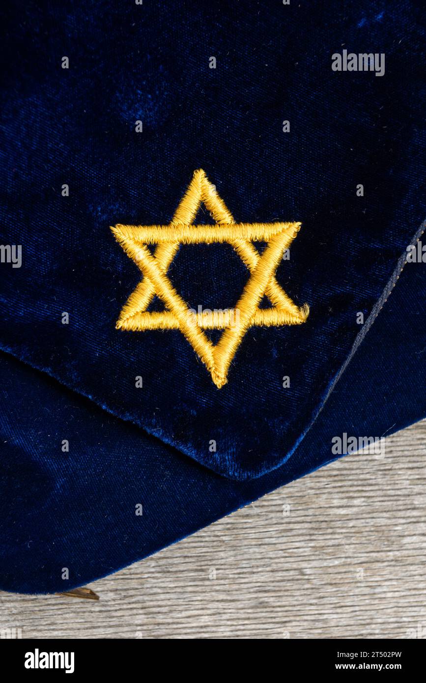 A yellow Jewish star of David is embroidered on a blue, felt bag used ...