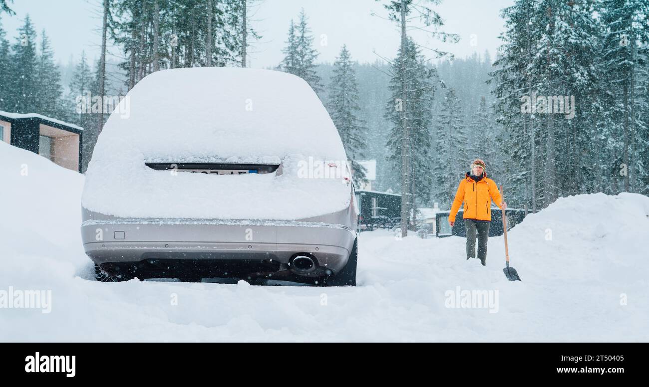 Car covered with snow as a huge snowdrift on the countryside forest ...