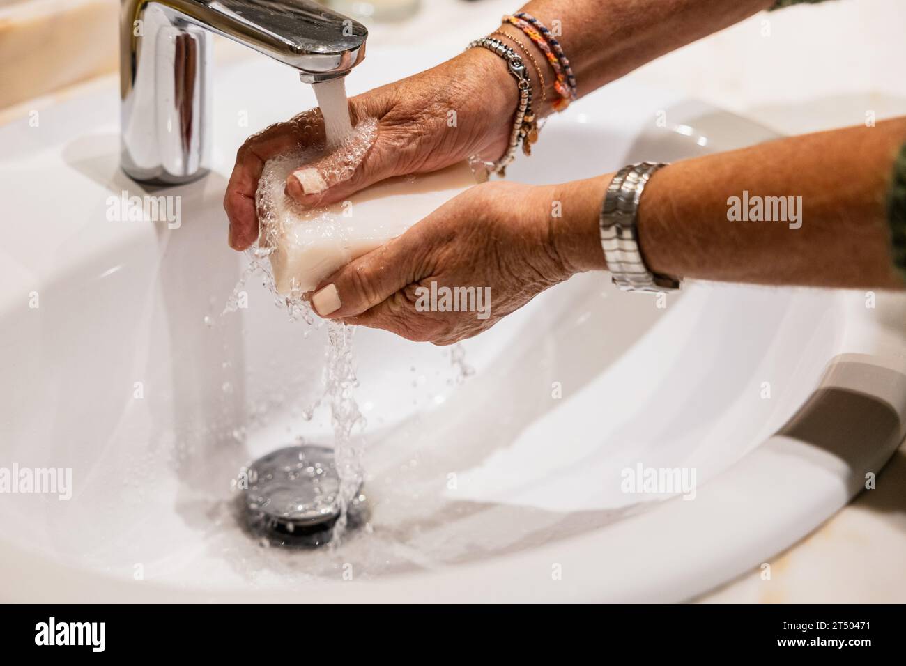 Elderly woman washing hands hi-res stock photography and images - Alamy