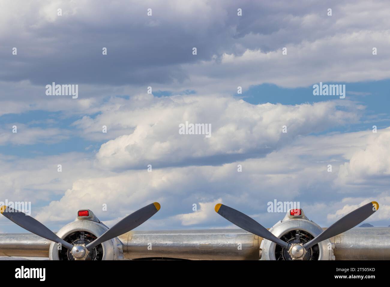 Under cloudy skies a section of an airplaine wing supporting two large ...