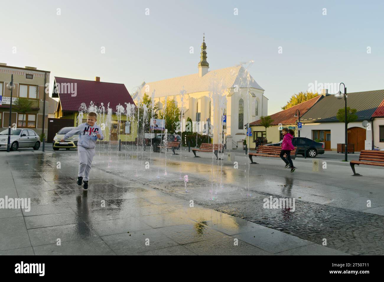 Children playing at the fountain on the town square in Bodzentyn ...