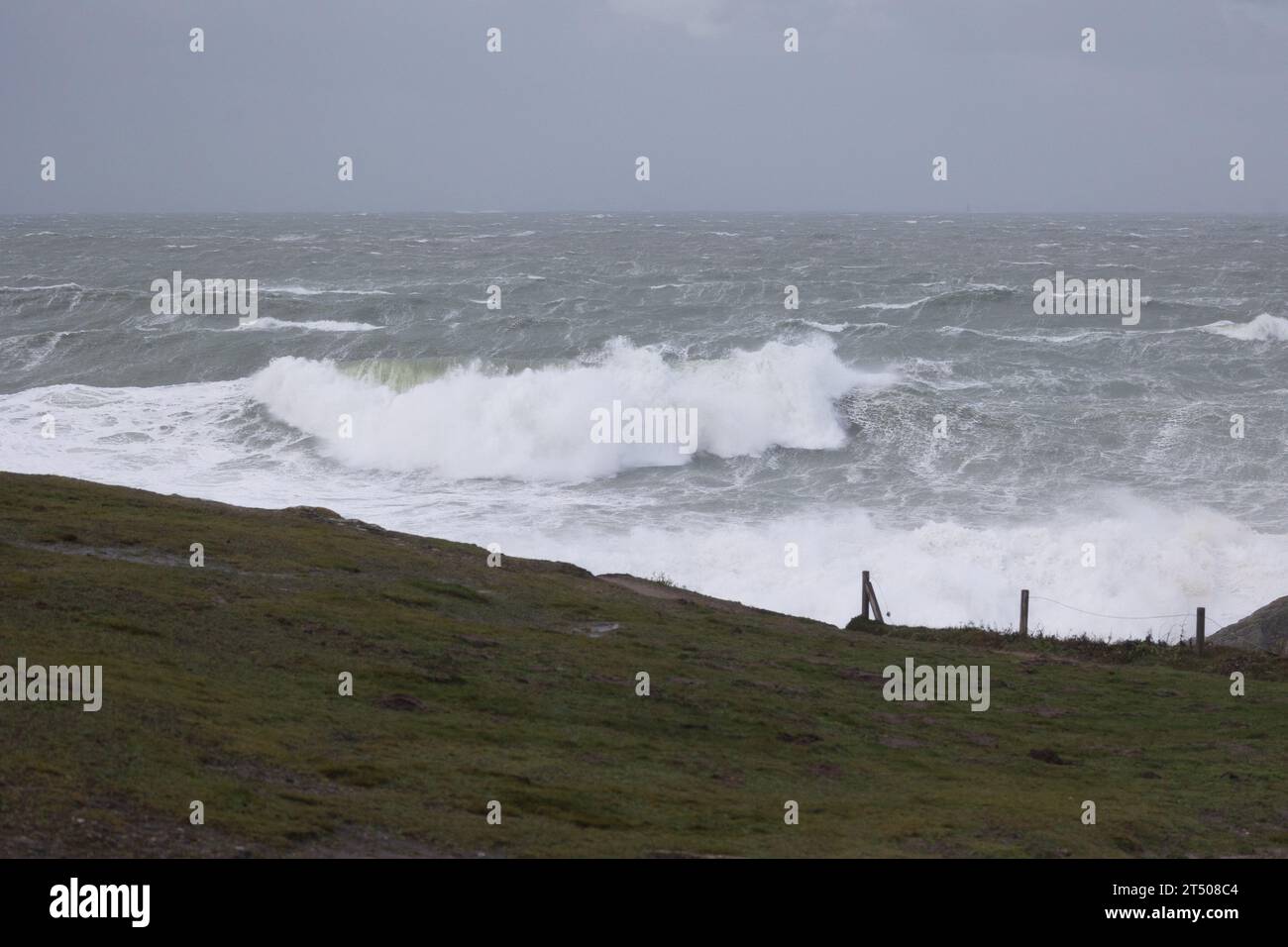 People look at waves hitting the waterfront around Quiberon, western France, on November 2, 2023 ...
