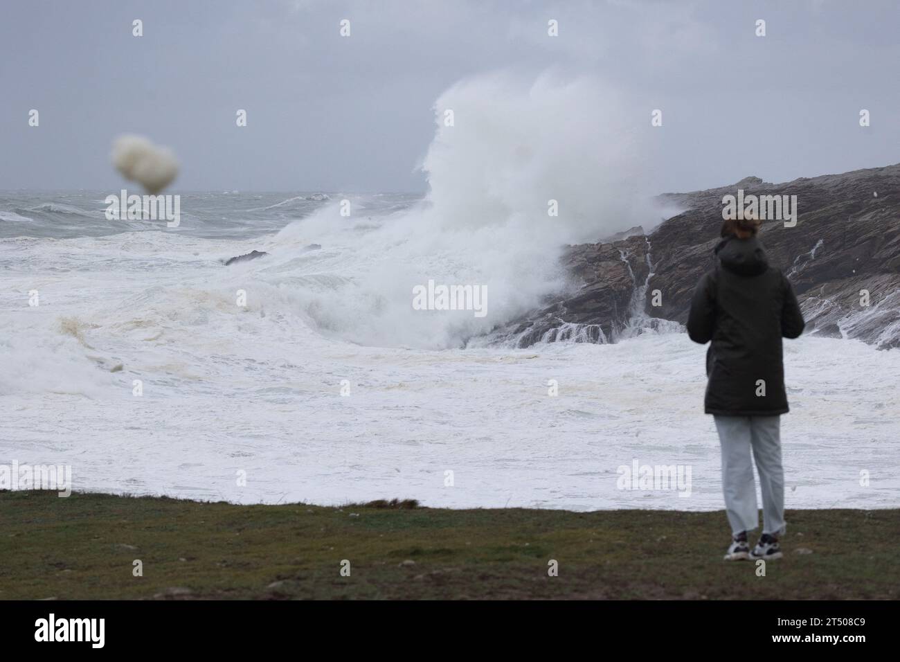 People look at waves hitting the waterfront around Quiberon, western France, on November 2, 2023 ...