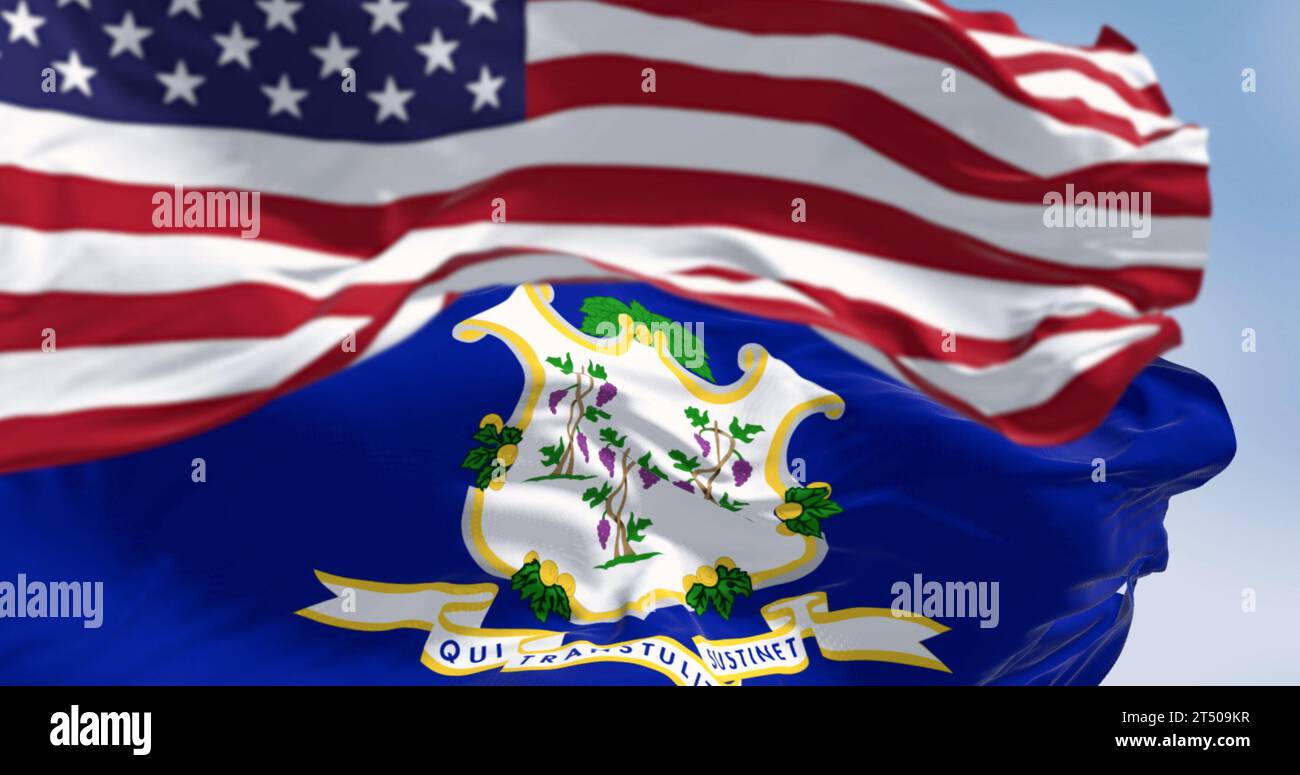 Connecticut and the United states flags waving in the wind on a clear ...