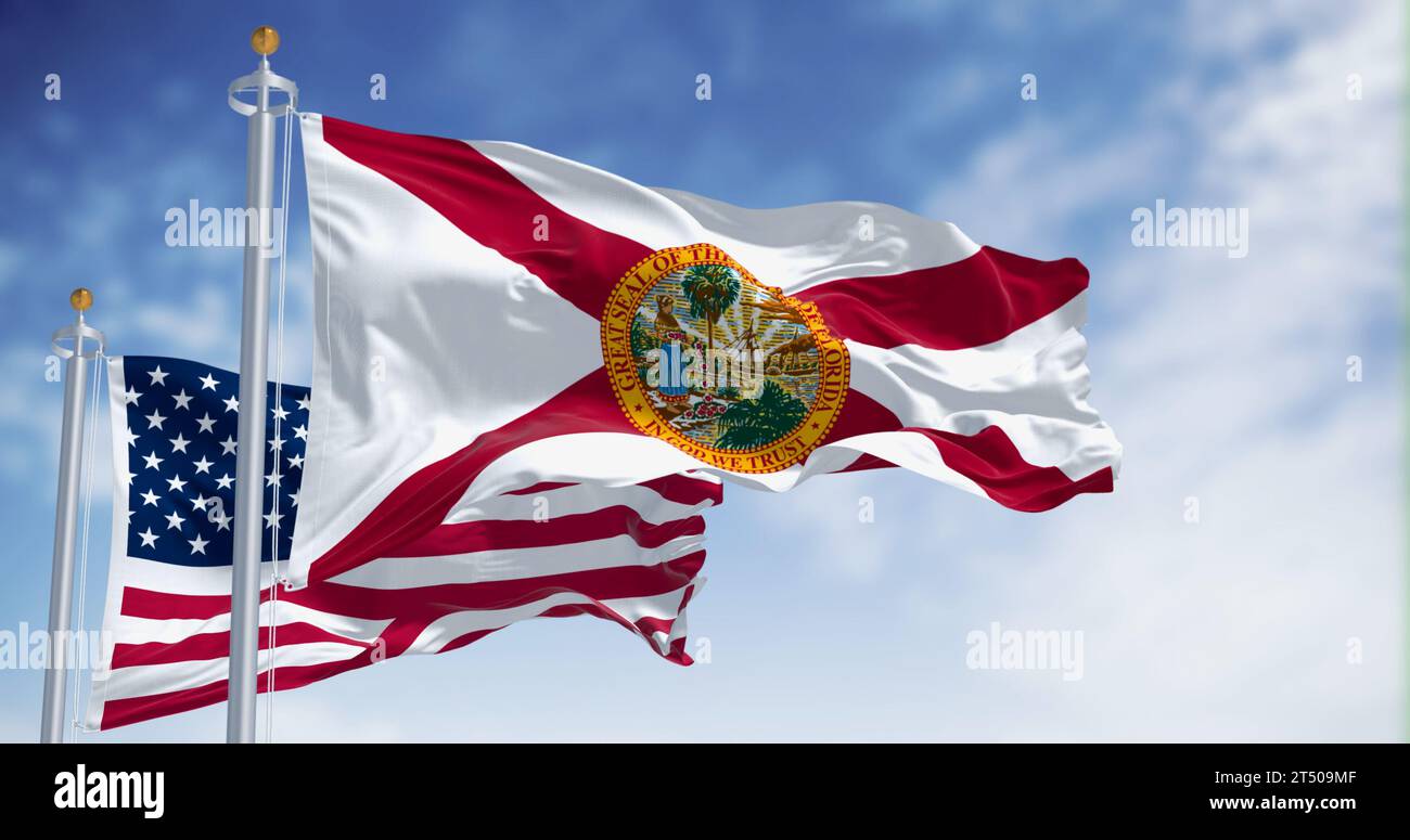 Flags of Florida and United States waving in the wind on a clear day ...