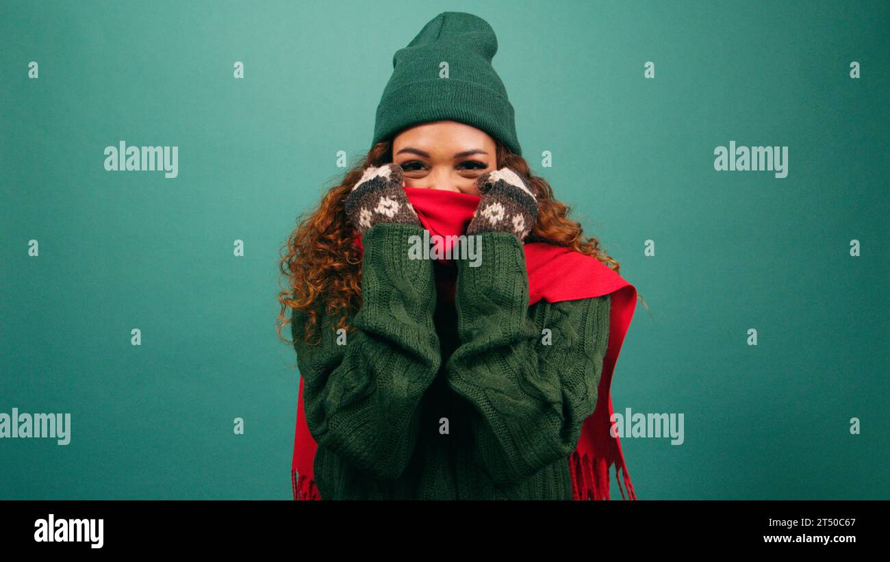 Freezing cold woman bundles up against the cold, huddles in warm scarf ...