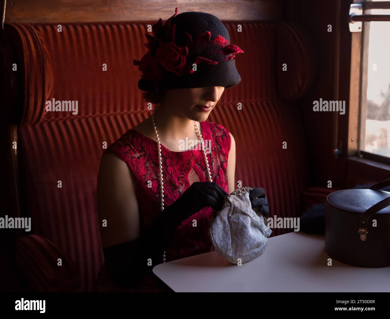 Attractive 1920s woman in red flapper dress and cloche hat posing in ...
