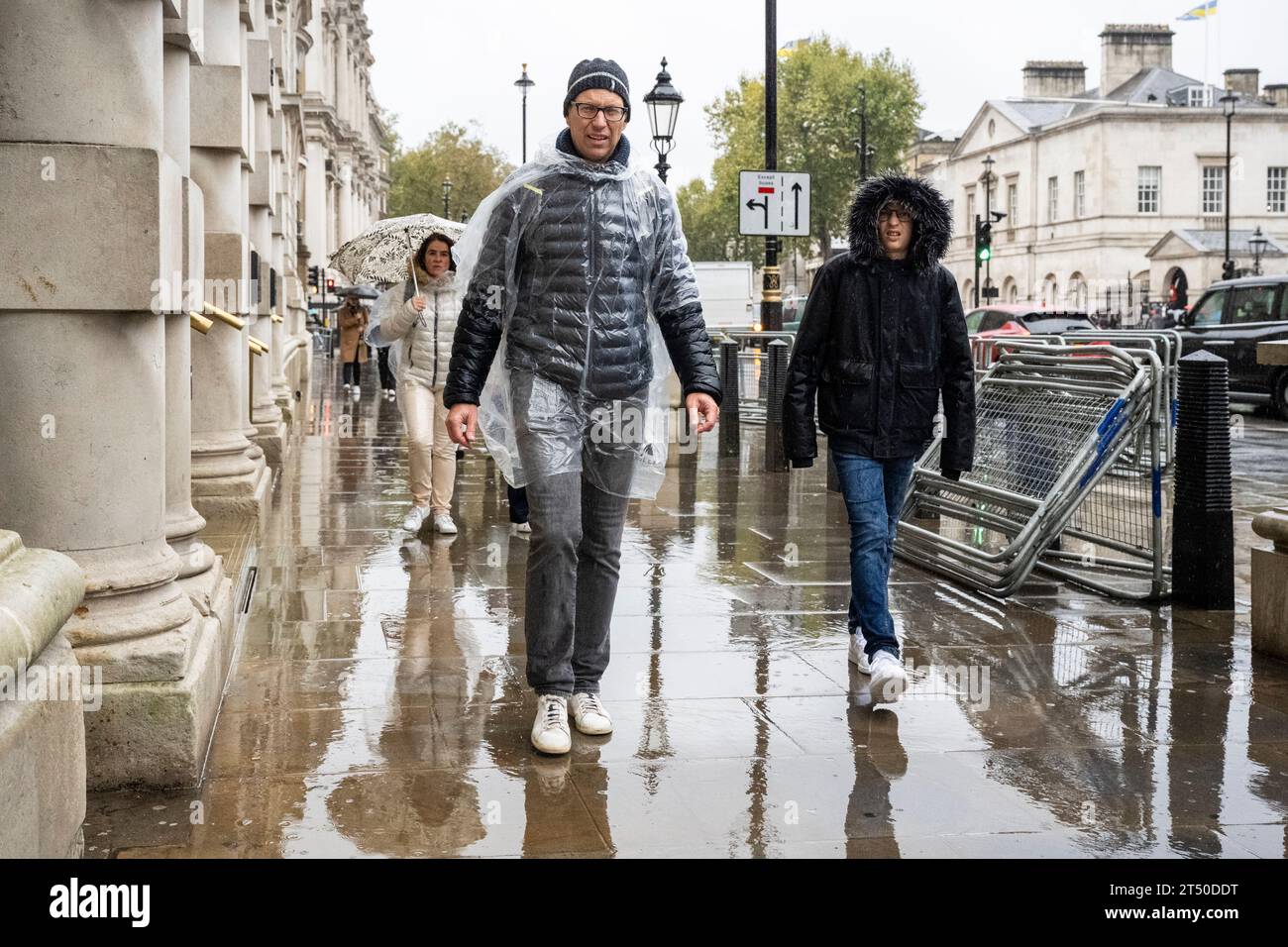 London, UK. 2 November 2023. UK Weather - Tourists in Whitehall caught ...