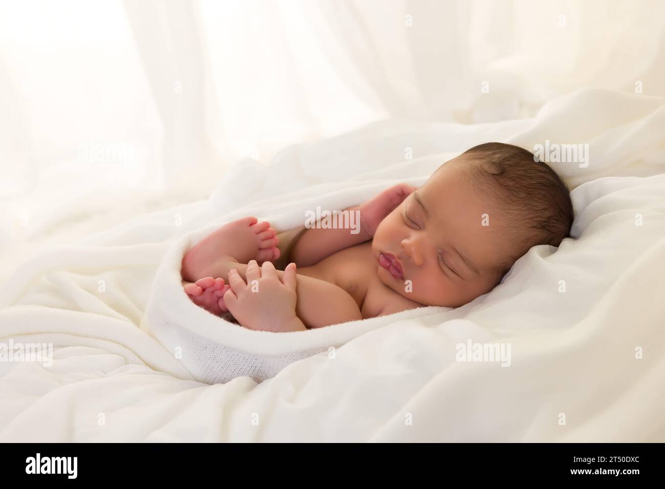 Cute little sleeping African biracial newborn baby sleeping on a white ...