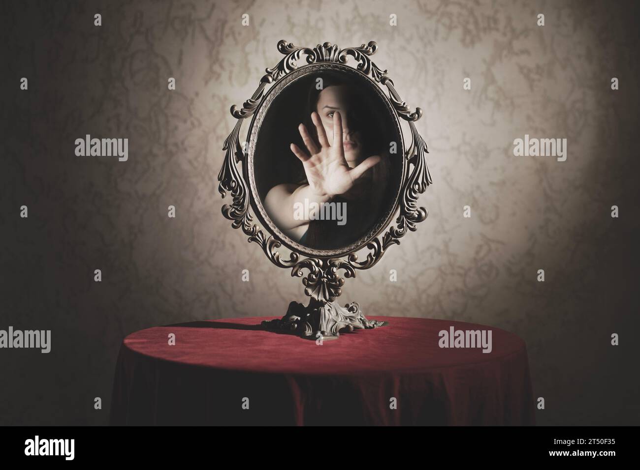 mirror reflecting a woman opening her hand in a stop sign; abstract ...
