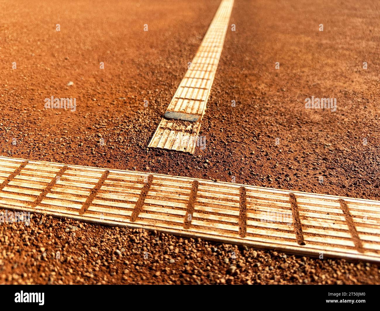 Detailed macro view of clay tennis court corner with white lines cross ...