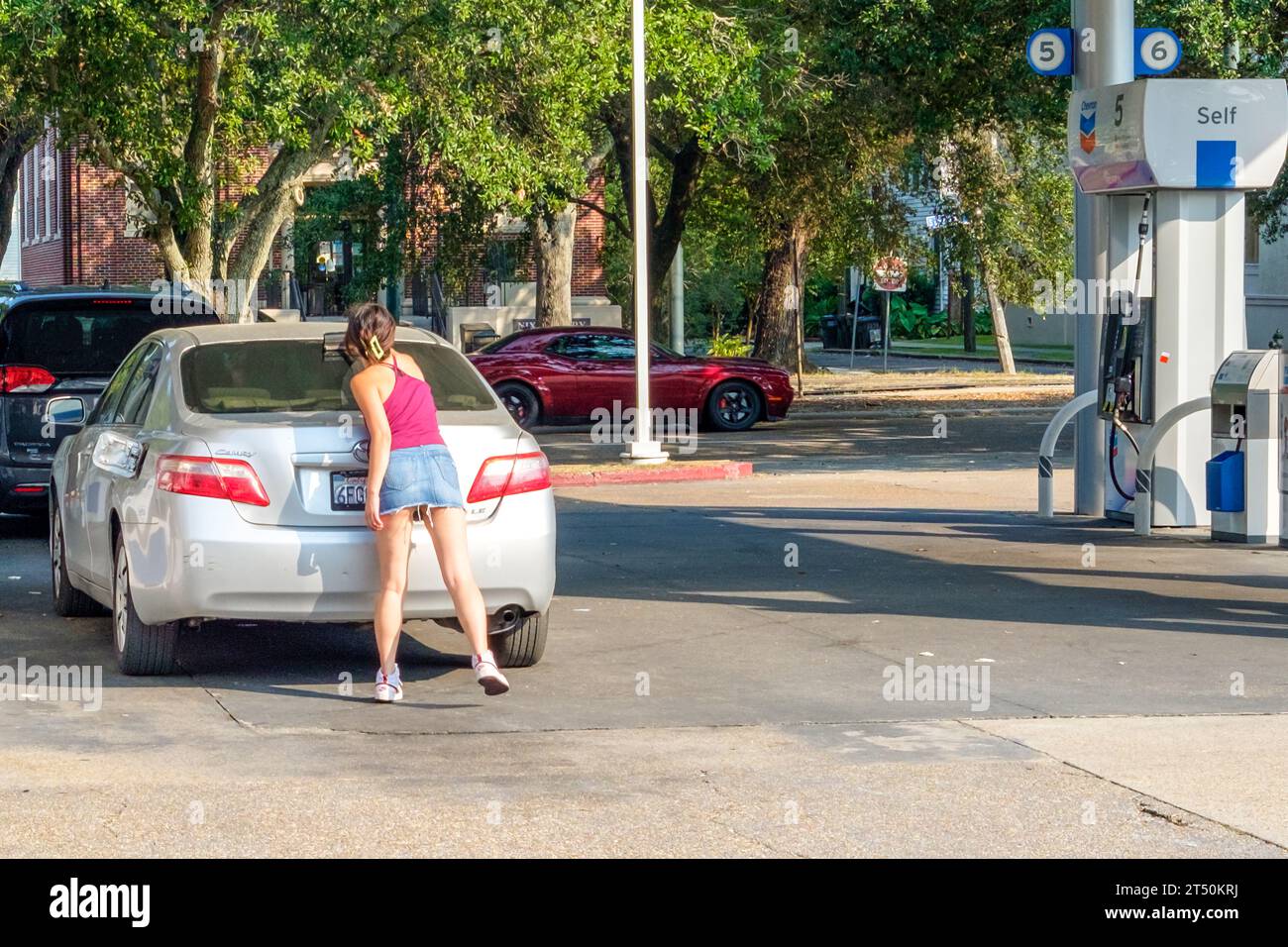 NEW ORLEANS, LA, USA - AUGUST 18, 2023: Young woman cleaning rear car ...