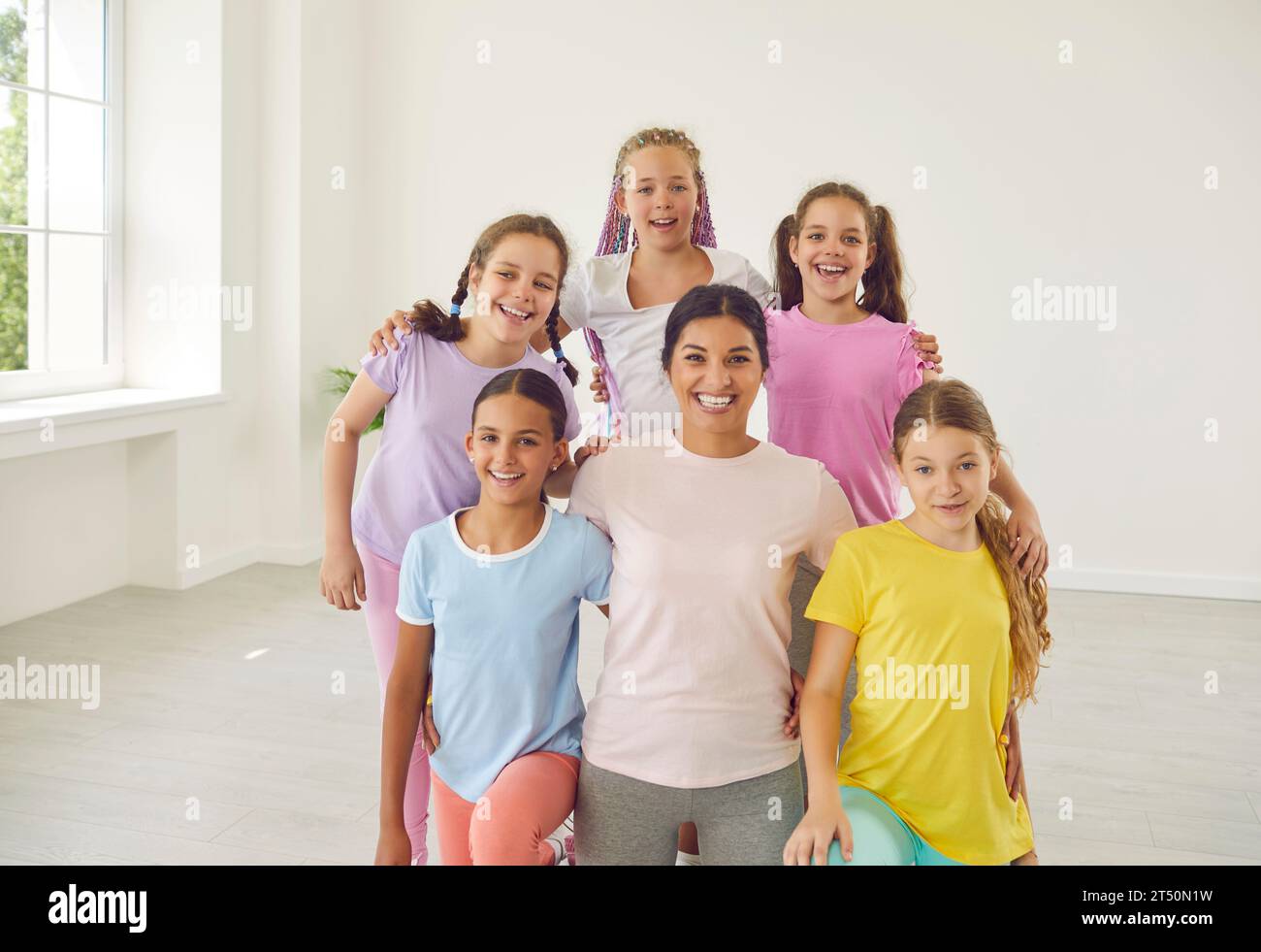 Group of happy little girls together with their dance teacher or ...