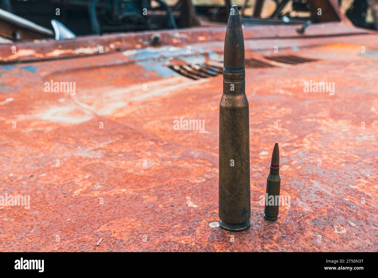 A rifle cartridge and a heavy machine gun cartridge on the hood of a ...
