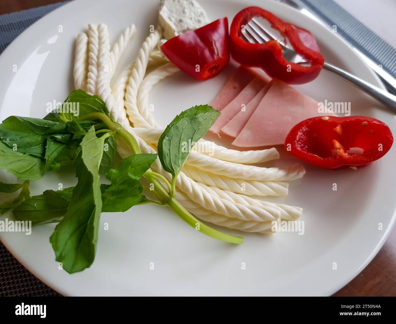 Turkish Helix String white Cheese with vegetables on plate with wooden ...