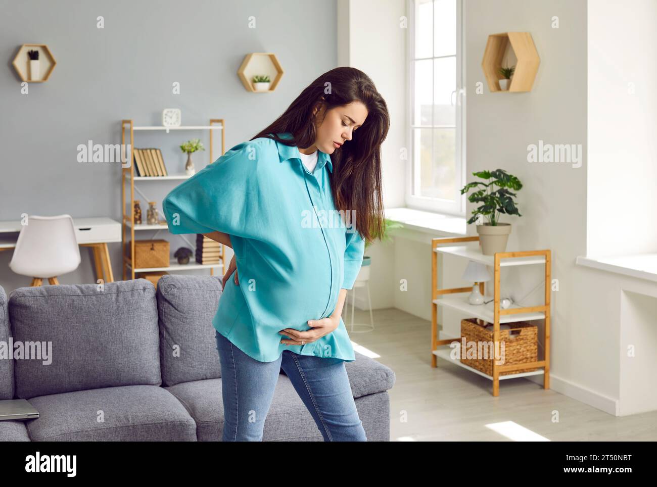 Young pregnancy woman having labor contractions pain touching her tummy ...