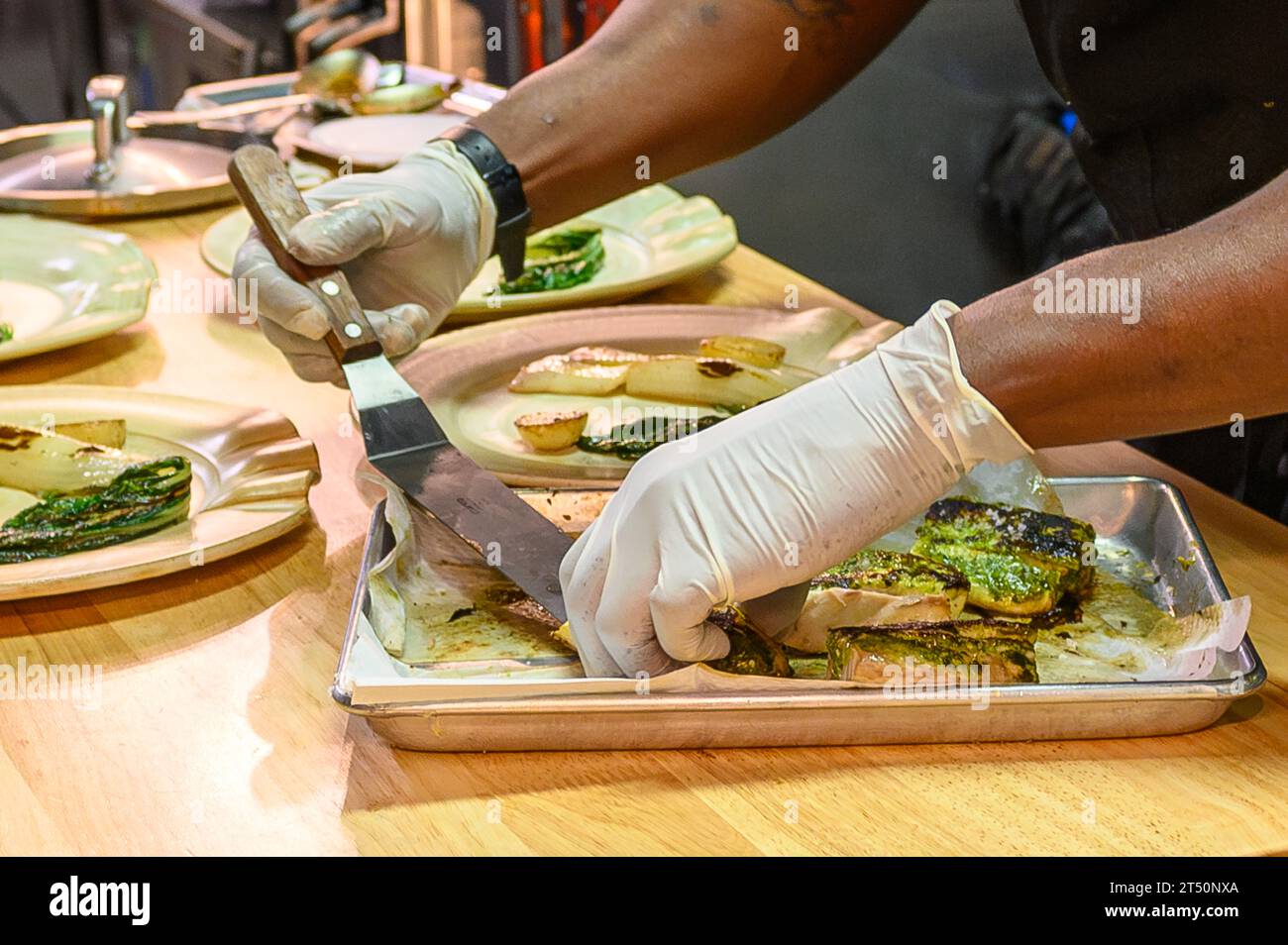 New Orleans, LA, USA - November 1, 2023: Chef's hands plate food in the ...