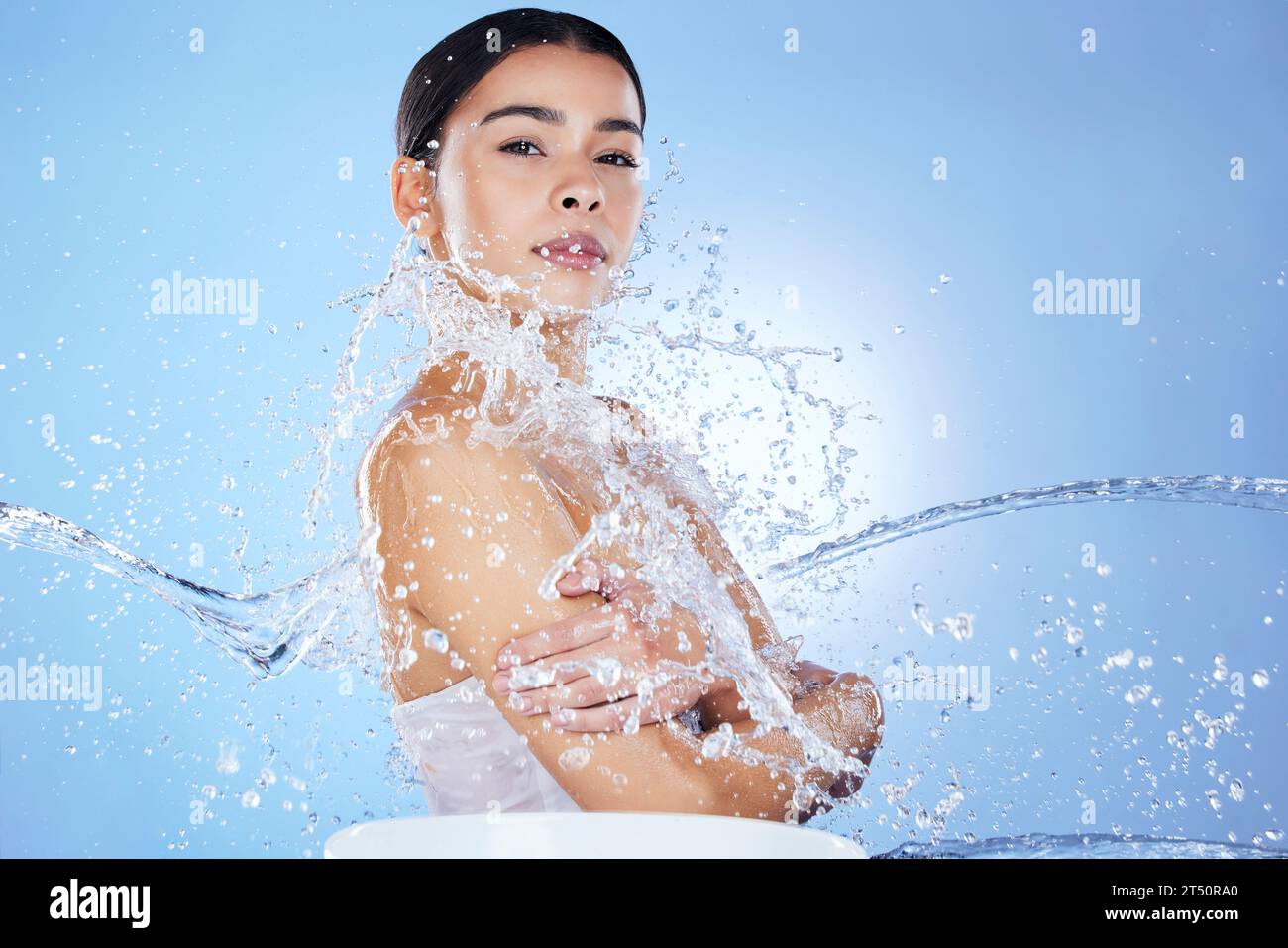 Beauty, skin care and portrait of woman water splash for glow results on blue background. Face ...