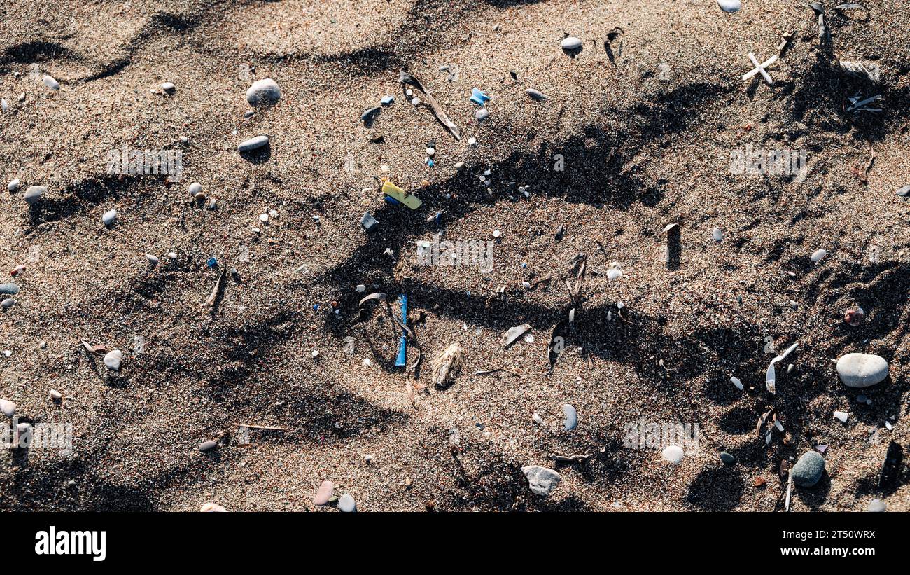 Top view of sand with pebbles and colored microplastics. The problem of ...