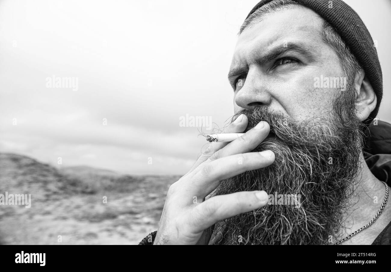 man with beard smoking cigarette, copy space banner. bearded man ...