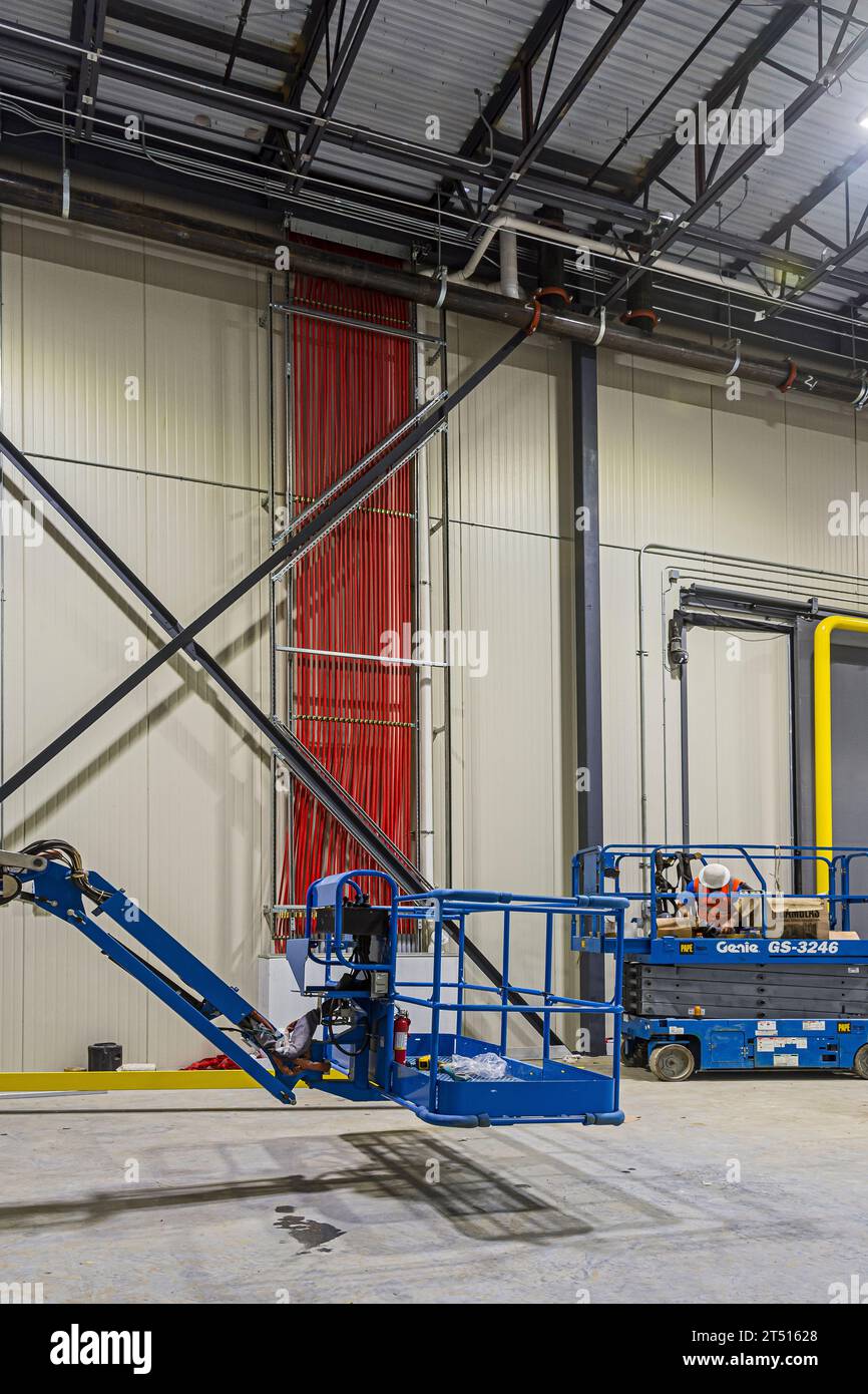 Red coolant hoses descend from the roof of a cold-storage facility to ...
