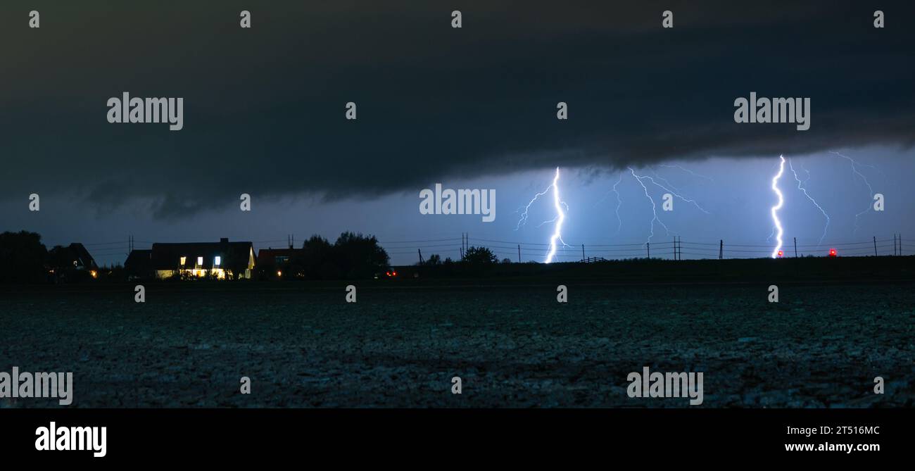 Dramatic image of two bright lightning bolts striking near a farmhouse ...