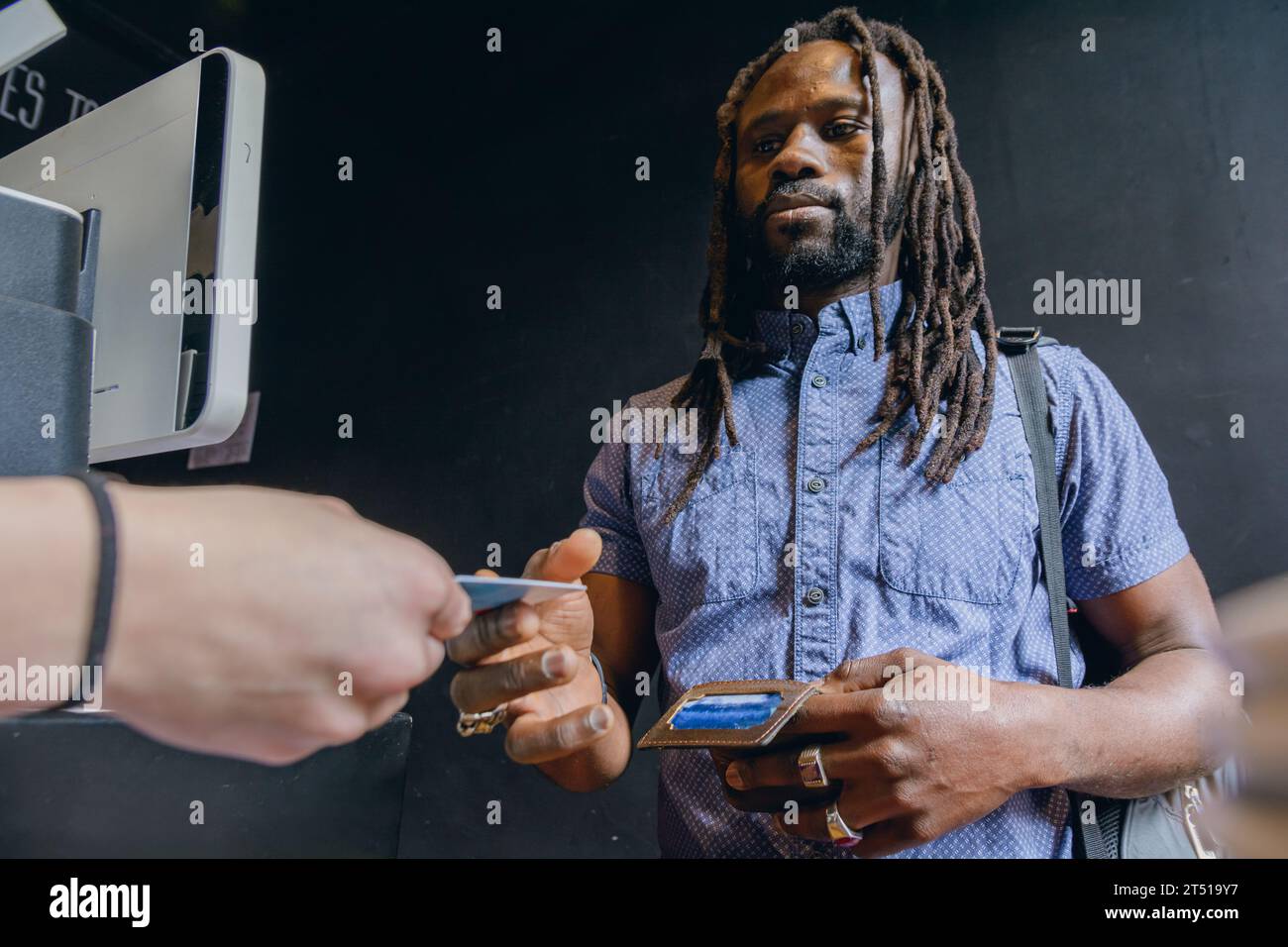 Black male customer of African ethnicity with dreadlocks and beard ...