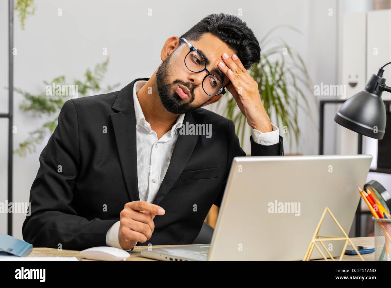 Irritated tired Indian business man while working on laptop, unexpected ...