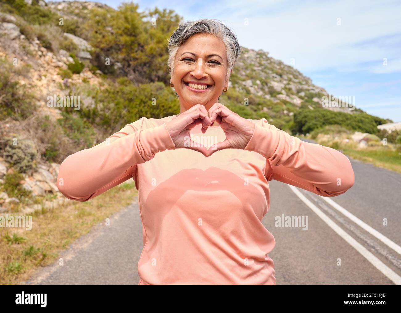 Senior woman, heart hands and runner on road for fitness, love icon and ...