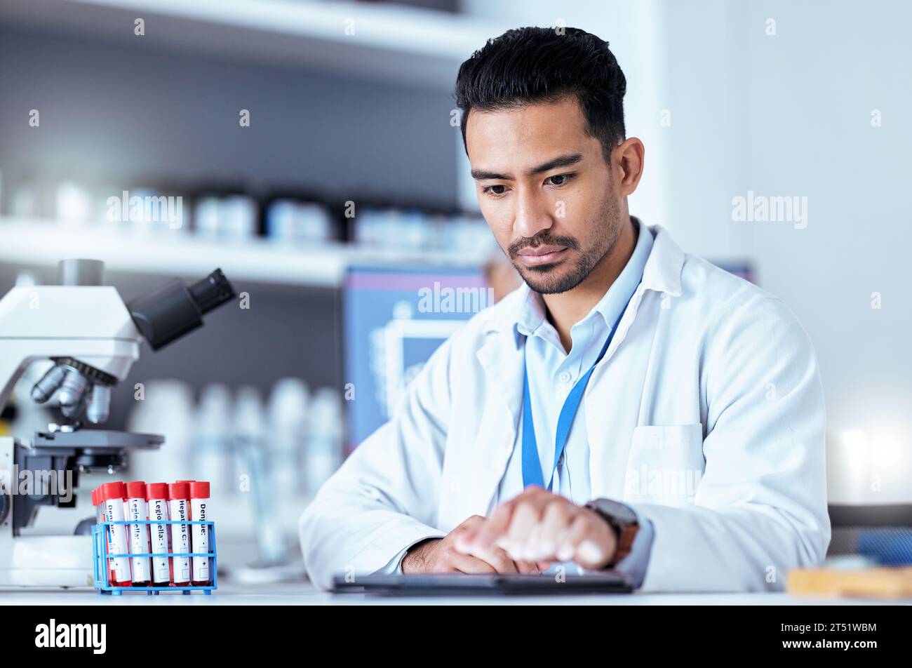 Scientist man, tablet and typing in laboratory with thinking, medical ...
