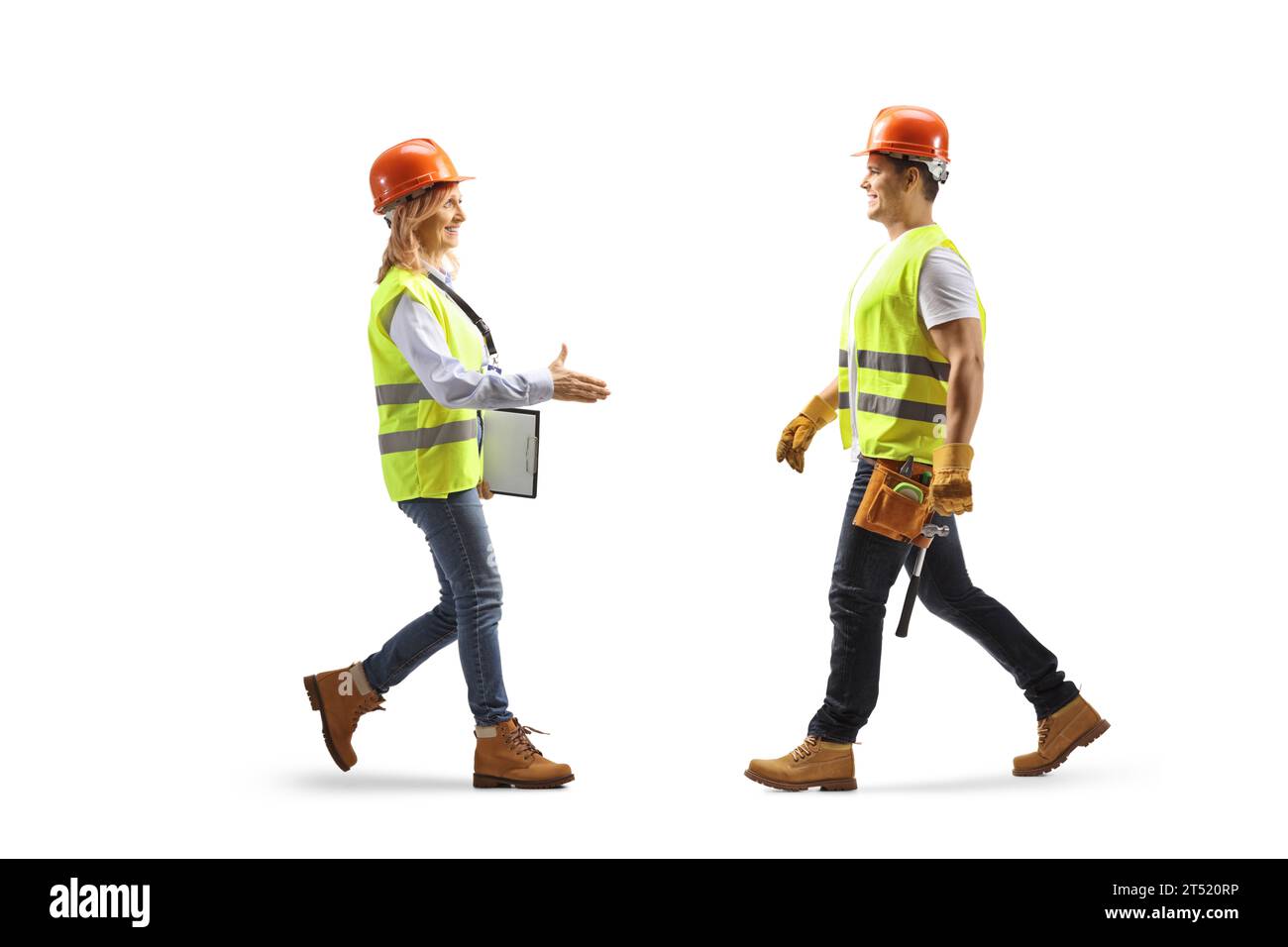 Full length profile shot of a female engineer walking and greeting a ...