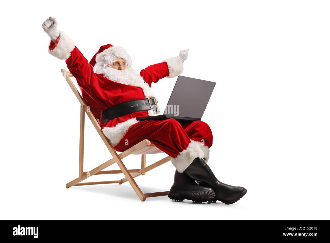 Happy santa claus sitting on a deck chair and using a laptop computer ...