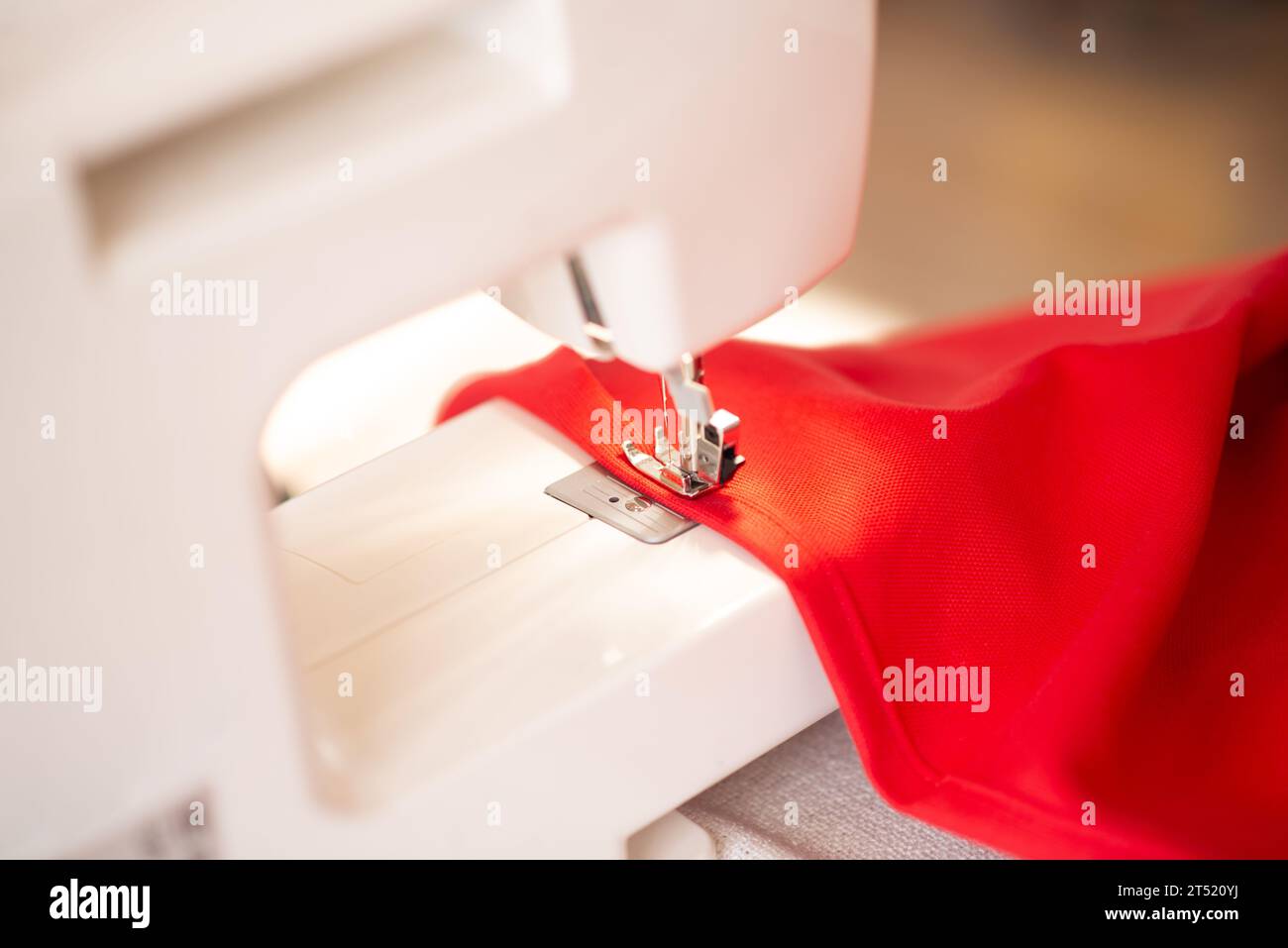 Sewing machine with red cloth closeup. sewing process in the re ...