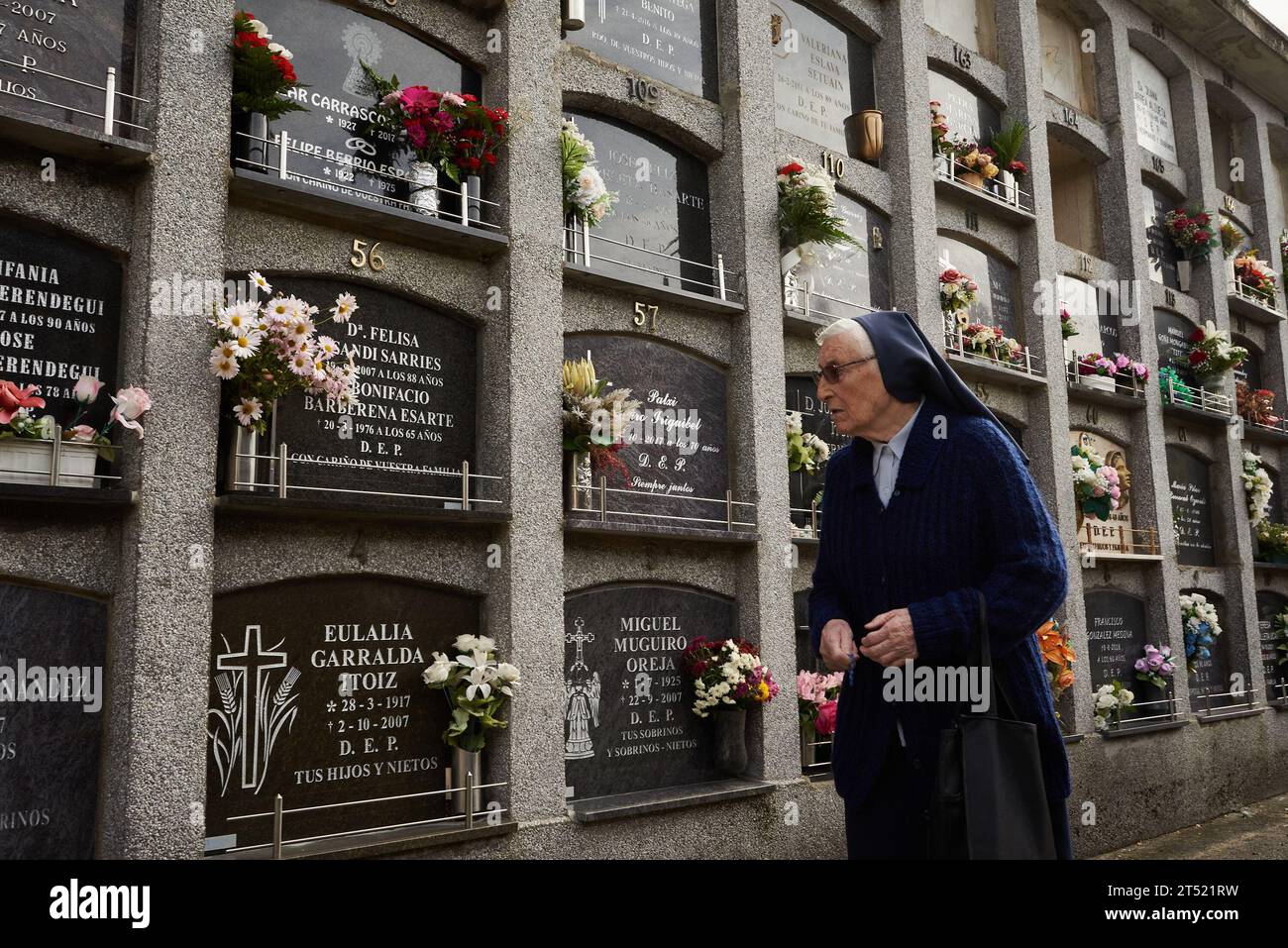 A nun walks through the niches of the Pamplona cemetery during the ...