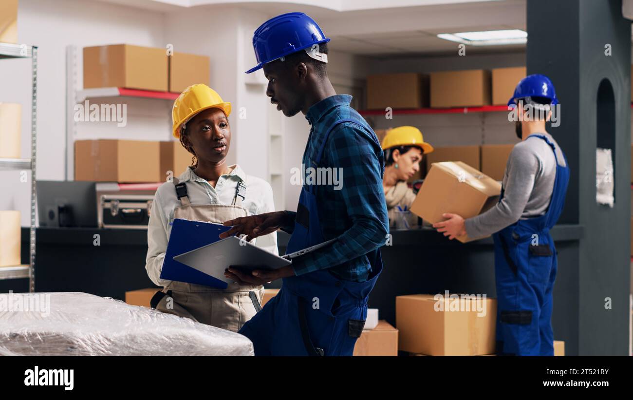 African american people doing quality control in warehouse, working ...