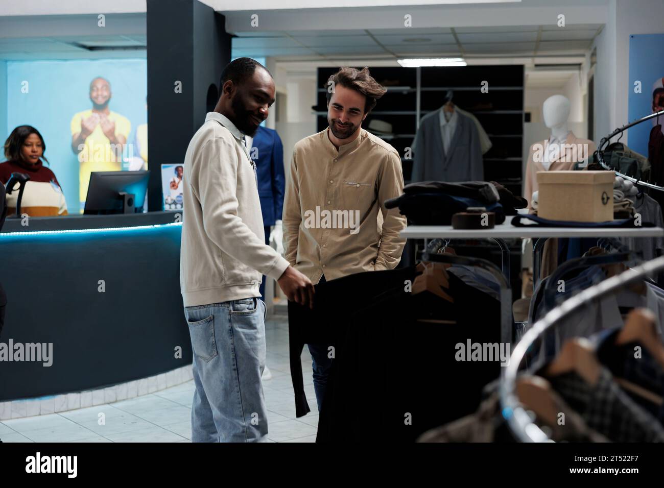 Clothing store smiling client and assistant discussing apparel style ...