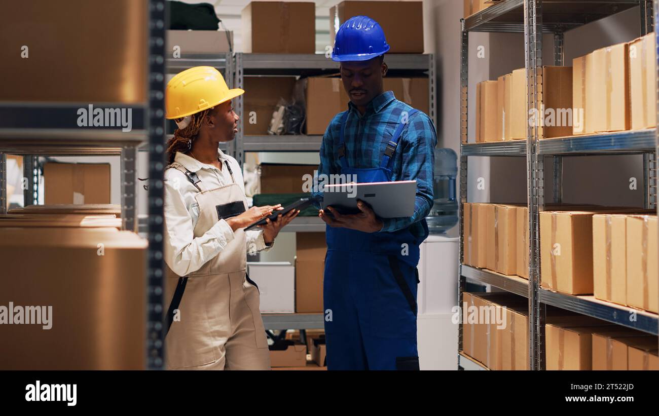 Two depot workers checking merchandise on shelves and planning order ...