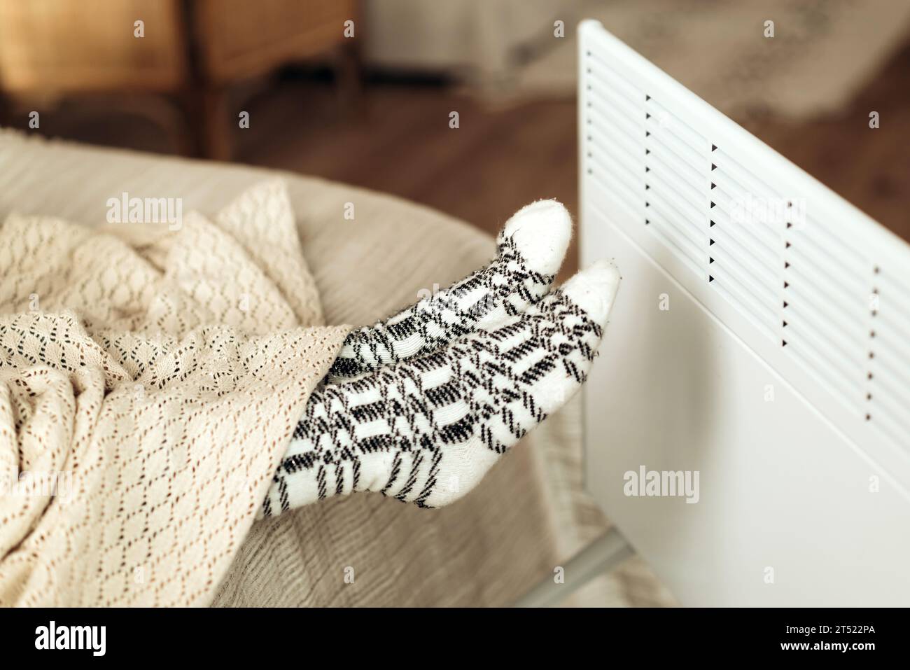 female feet in socks, in front of electric heater close up. cold ...
