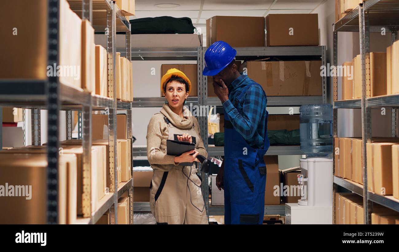 Diverse team of employees using tablet to scan products, pointing ...