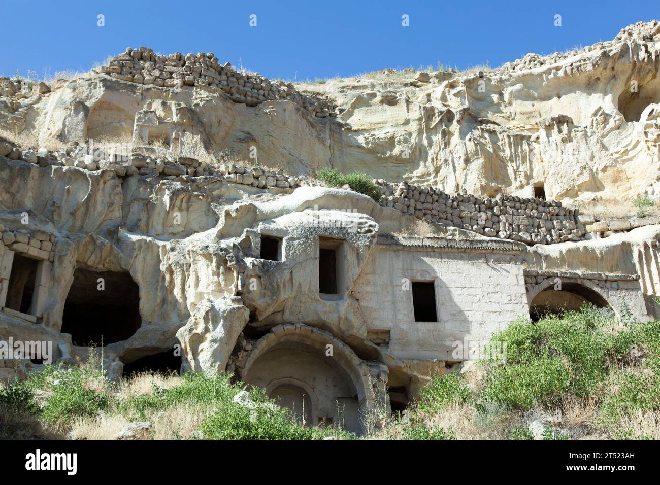 The view of Cavusin village old houses carved inside soft rock in ...