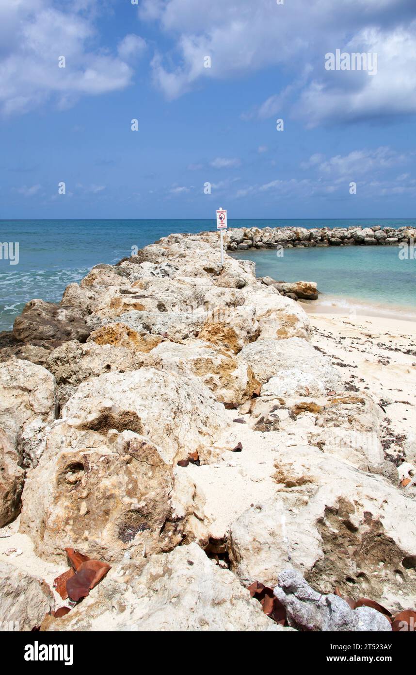 The view of a breakwater with a warning sign on Grand Cayman island ...