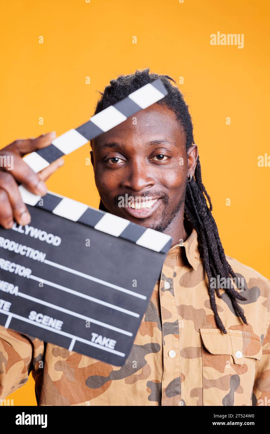 Portrait of producer holding clapperboard to cut scenes in movie making ...
