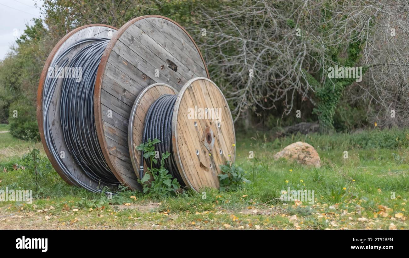 Large wooden spools of piping on the grass by the side of the road ...