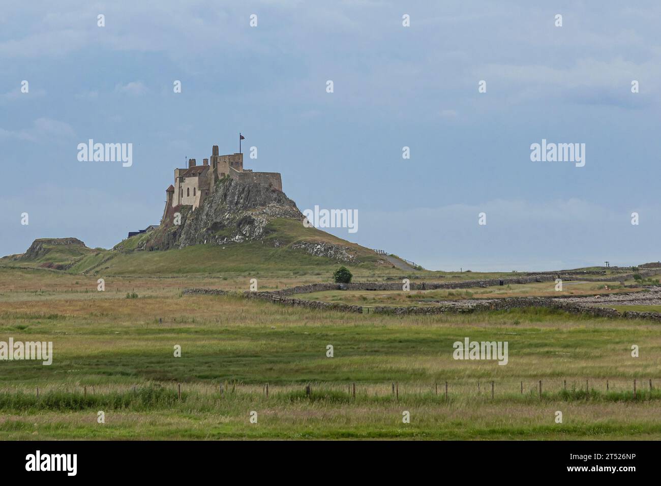 The castle of Lindisfarne on Holy Island on a hillside flying a union ...