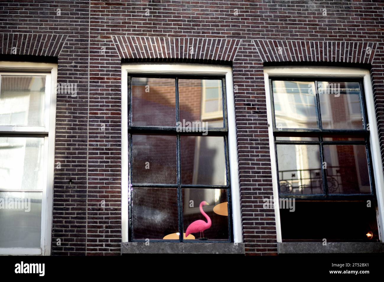 An interior scene of two windows within a room, with an object in one ...