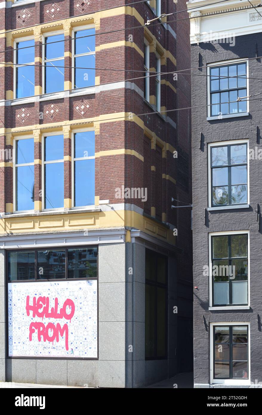 A large brown building with multiple windows and an advertisement on ...