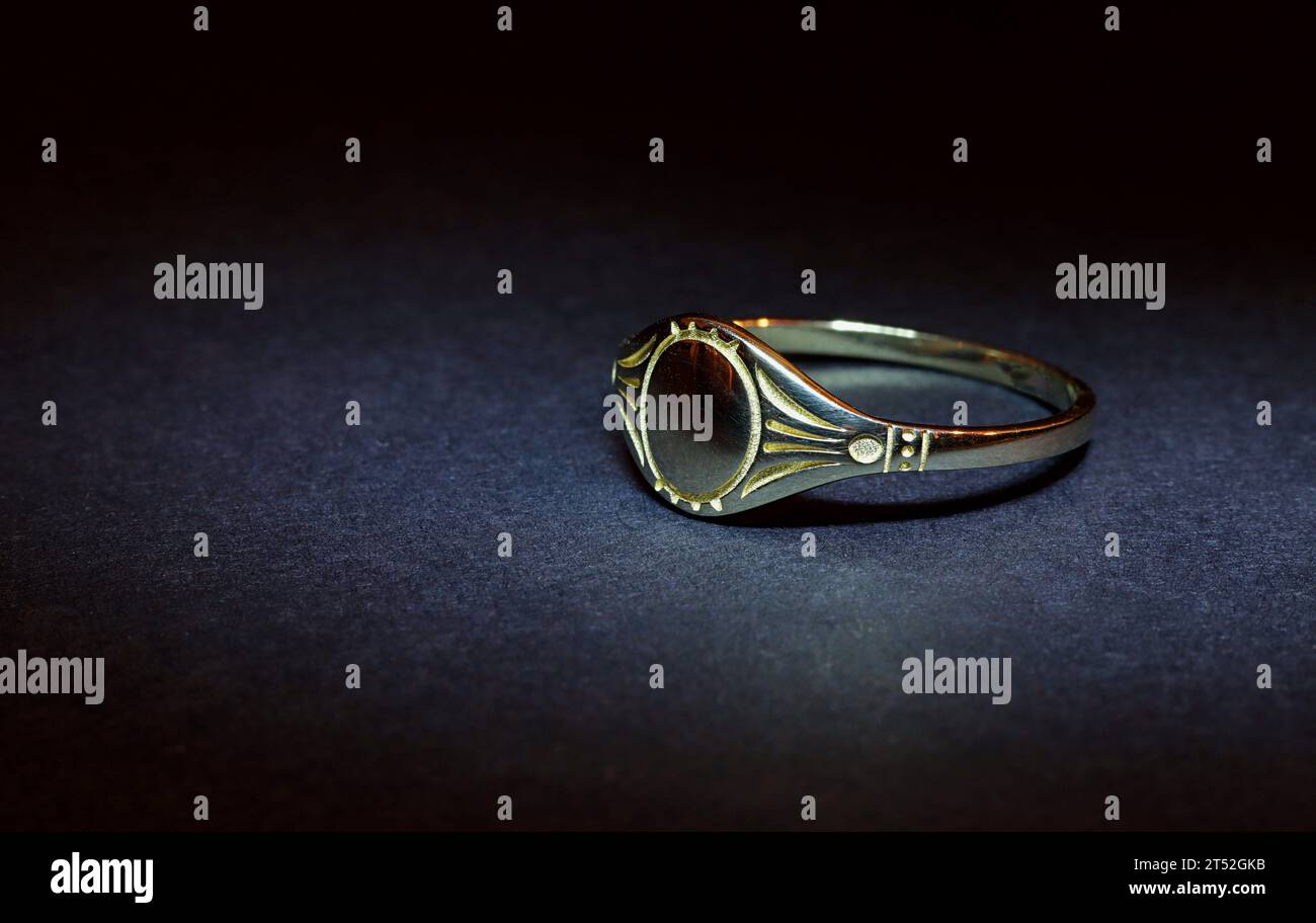 Women's gold signet ring with nice pattern on a black background Stock ...
