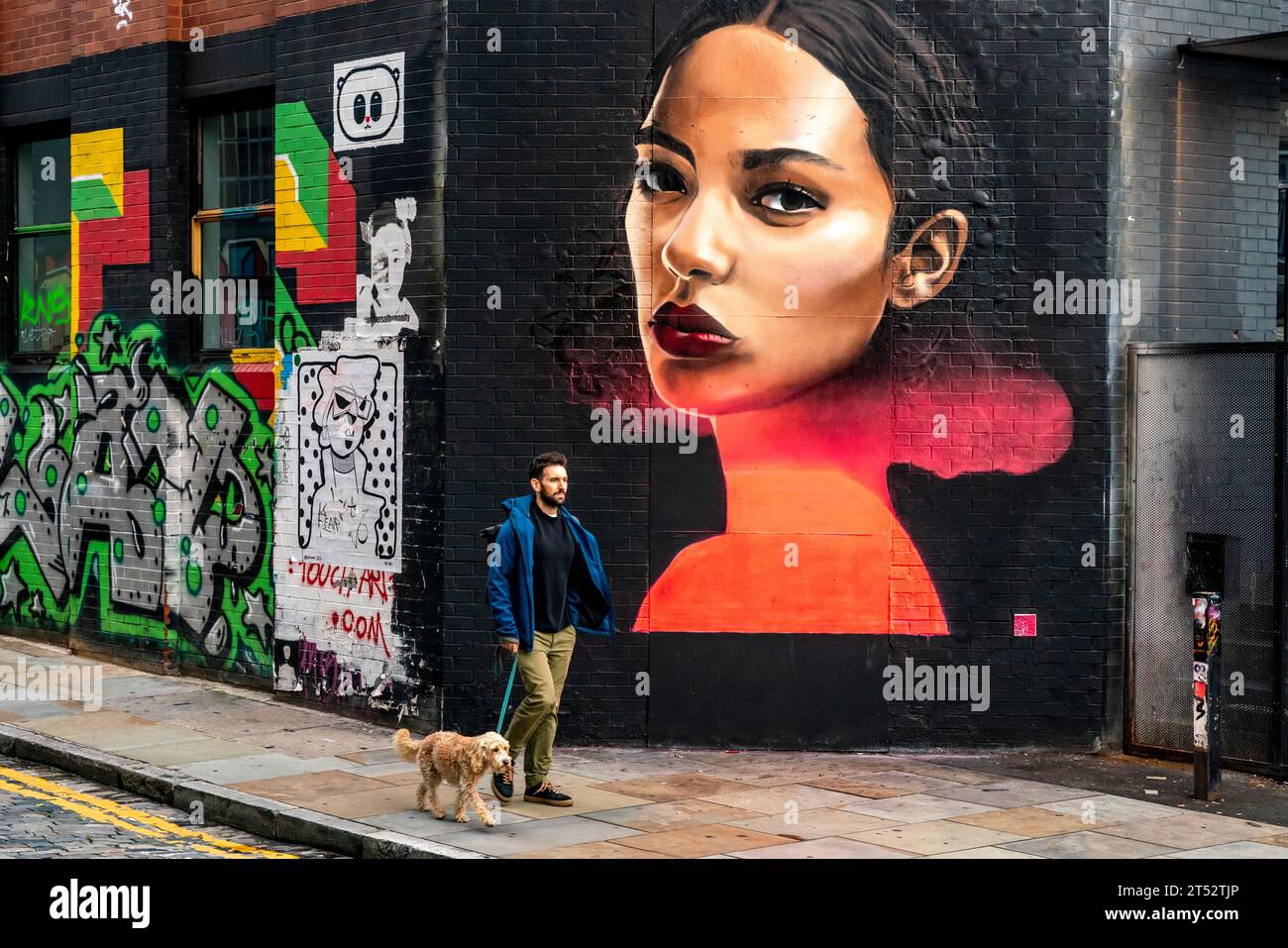 A Young Man Walking His Dog Past Some Colourful Street Art, Shoreditch ...