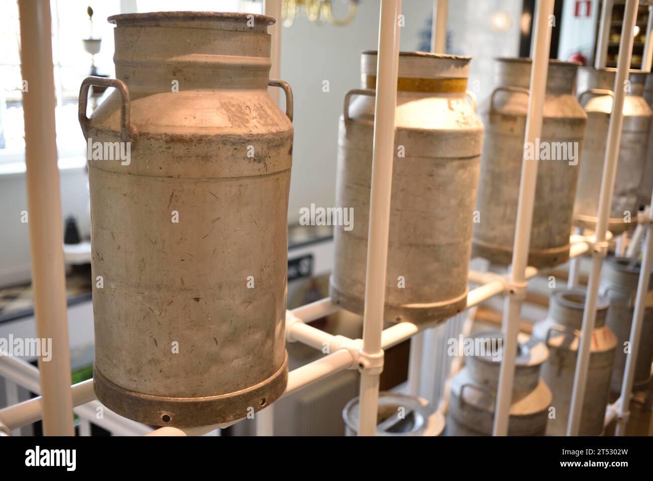 A composition of vintage galvanized milk cans, arranged in a neat stack ...