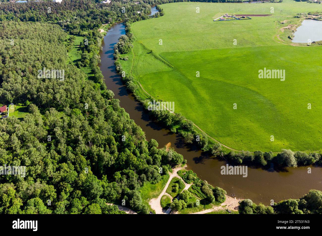 Scenic aerial view of a green landscape with a river separating the ...